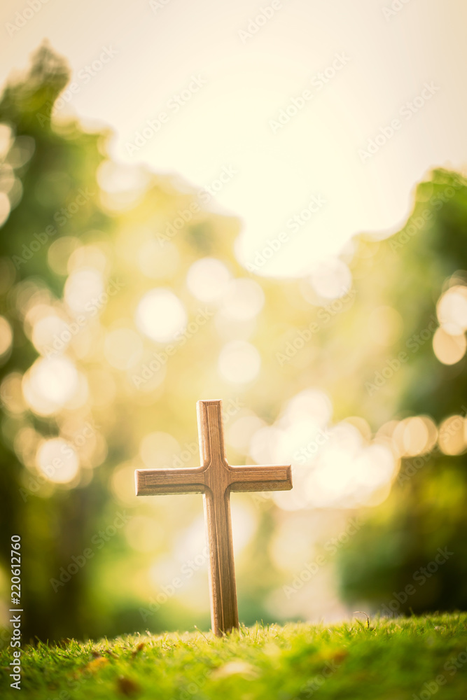 The cross standing on meadow sunset and bokeh background.Cross on a ...