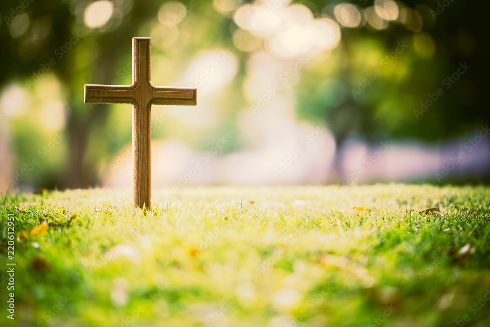 The cross standing on meadow sunset and bokeh background.Cross on a ...