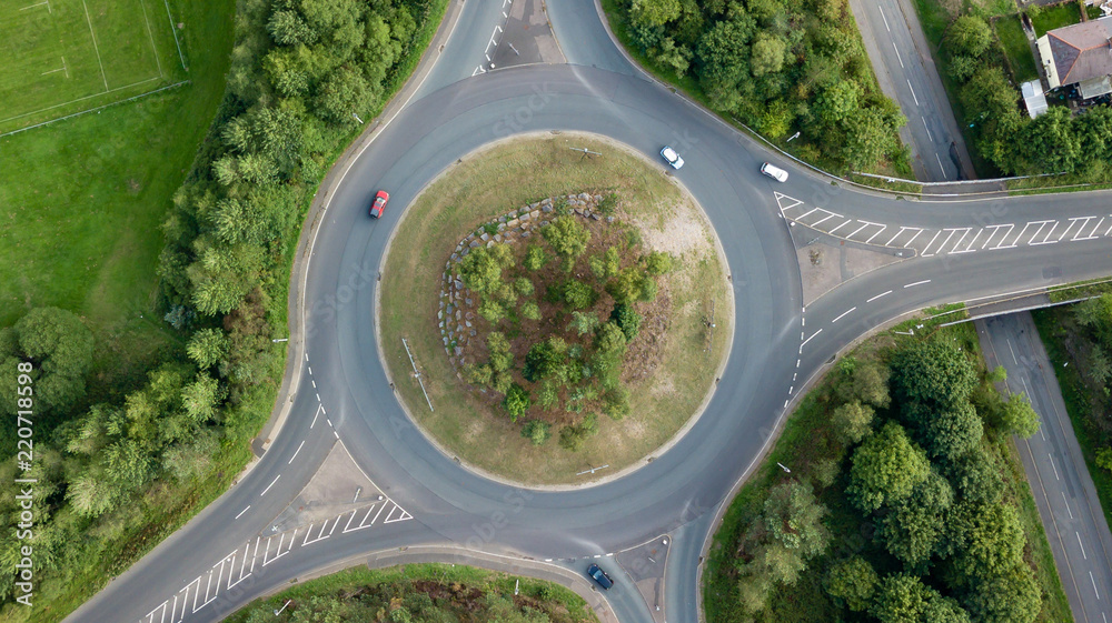 Top down aerial view of a traffic roundabout on a main road in an urban ...