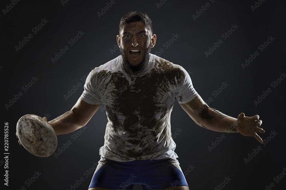 Isolated dirty rugby player with rugby ball on dark background Stock ...