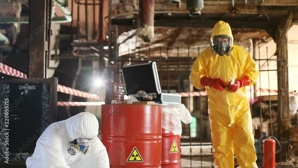 Vídeo do Stock: Two scientists wearing white and yellow hazmat suits ...