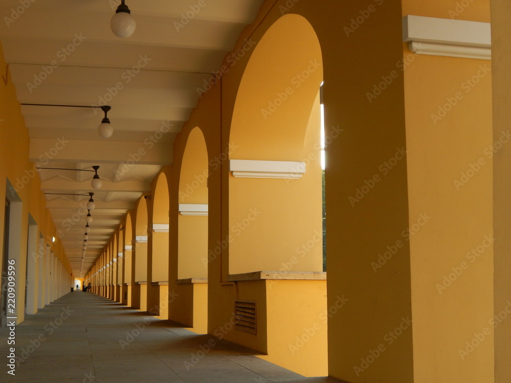 Long gallery with arches of yellow color, background Stock Photo ...