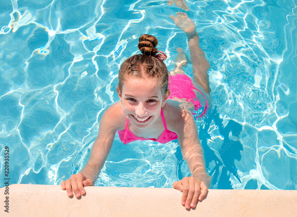 Teen girl in swimming pool squinting her eyes Stock Photo | Adobe Stock