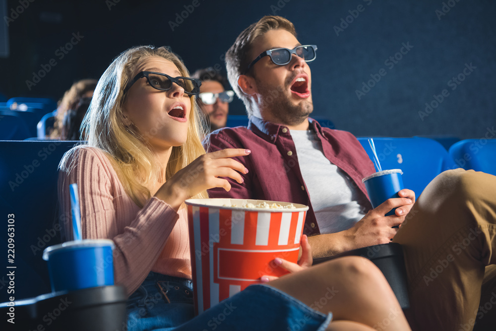 shocked couple in 3d glasses with popcorn watching film together in cinema Stock Photo | Adobe Stock