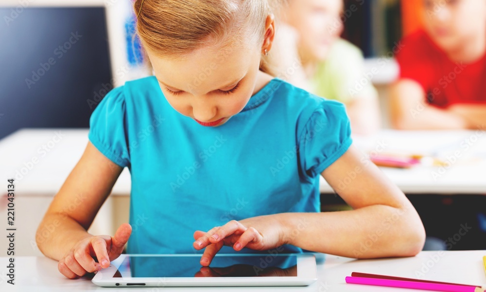 Smiling School Girl in the Classroom Using Tablet Stock Photo | Adobe Stock