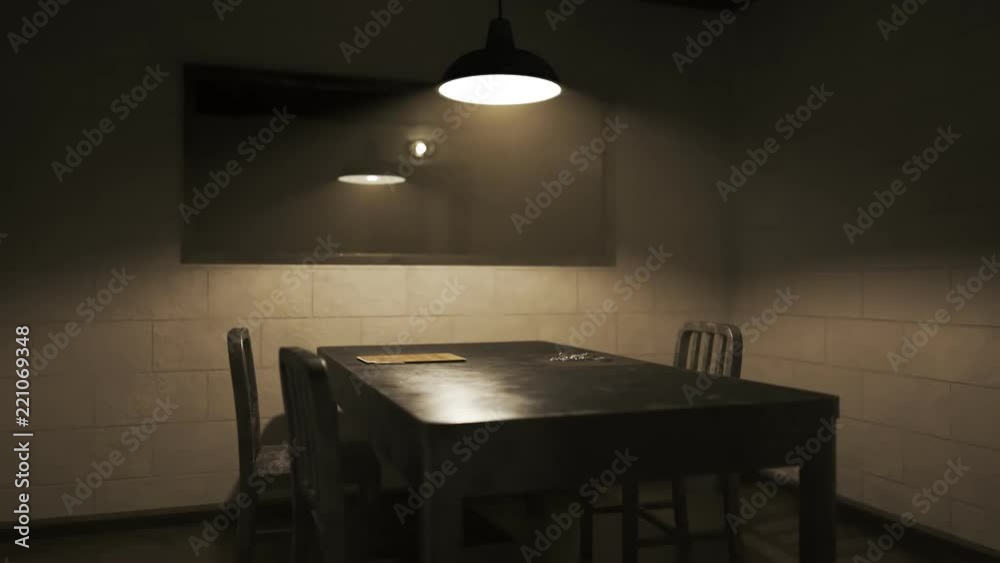 Dark, empty interrogation room seen through the one-way mirror ...