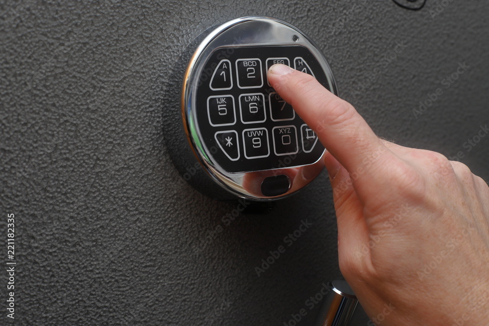 Hand enters combination on digital lock on a safe Stock Photo | Adobe Stock