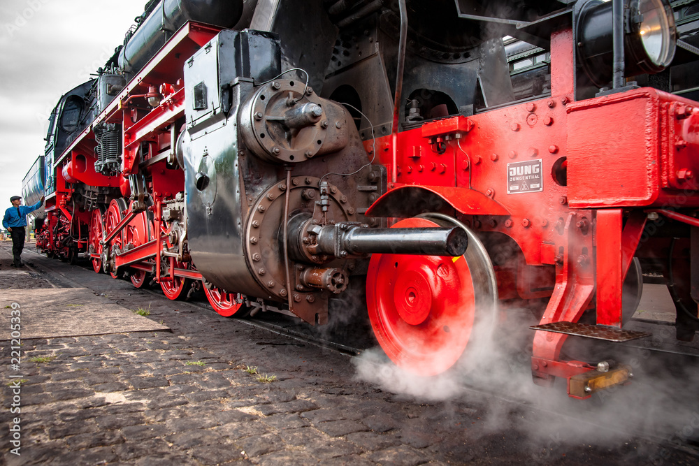 Steamy and rolling old locomotive with red steel wheels on on-site ...