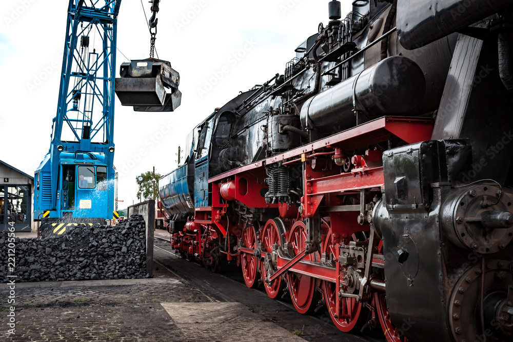 Steaming steam train or locomotive is waiting for coal loading by a ...