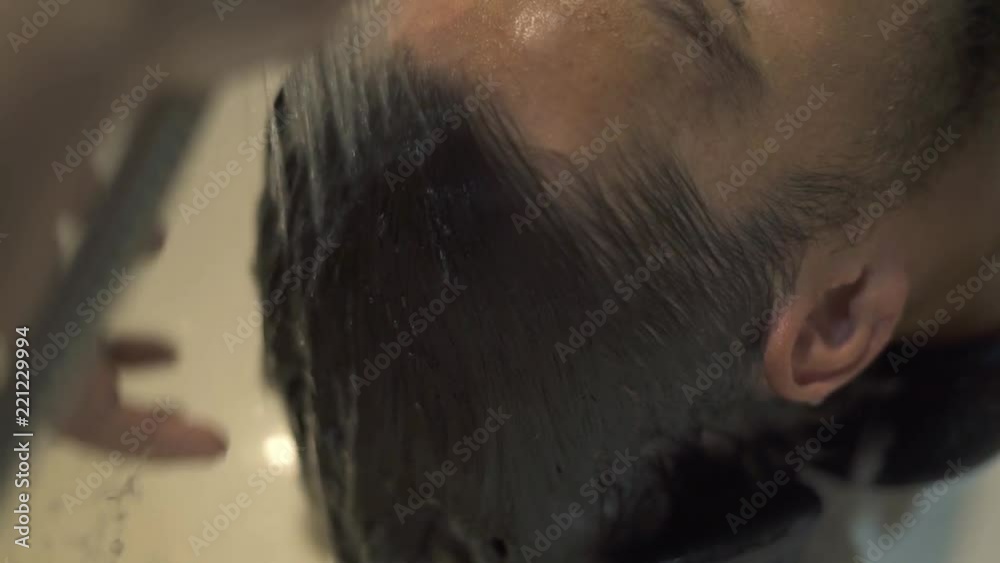 Washing male hair in barber salon. Hairdresser hand wash male head ...