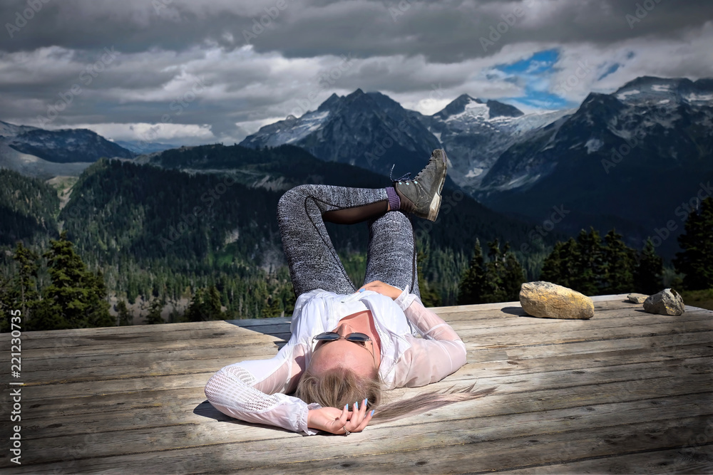 Carefree woman lying down among mountains, taking nap. Hiking mountains ...