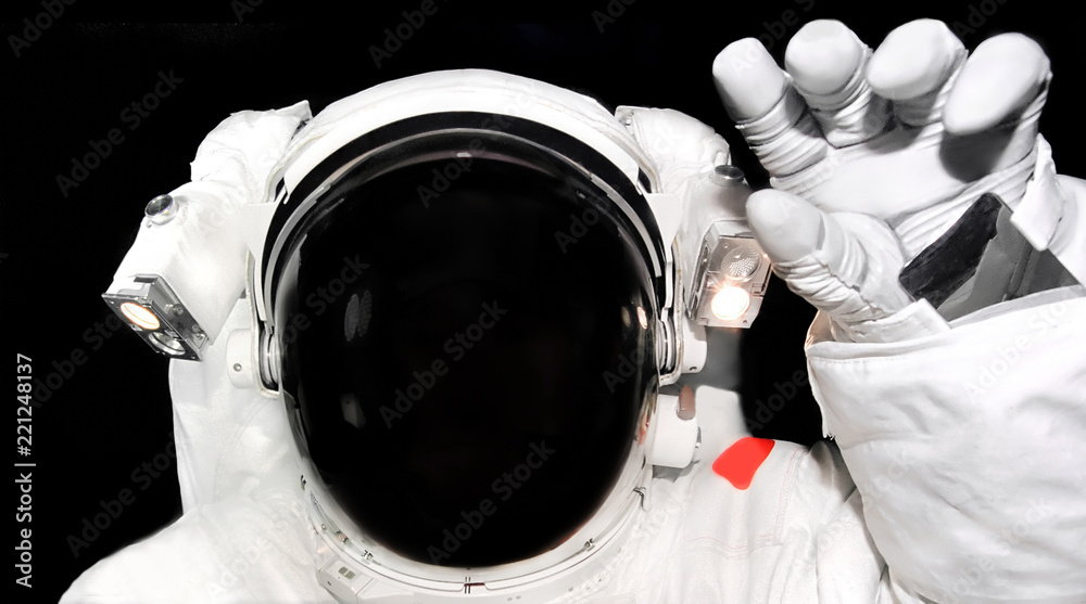 Astronaut in spacesuit raised his hand for a greeting. Spaceman close ...