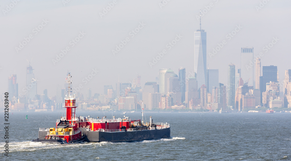 Freight tug pushing cargo ship to the port in New York City and Lower ...