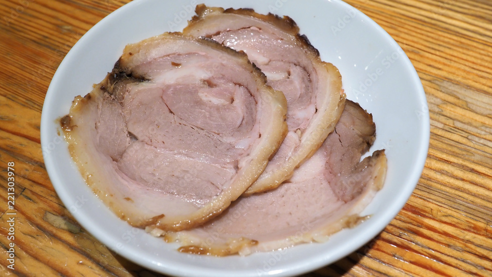 Chashu pork 3 pieces slice on the white color dish and wood table which ...