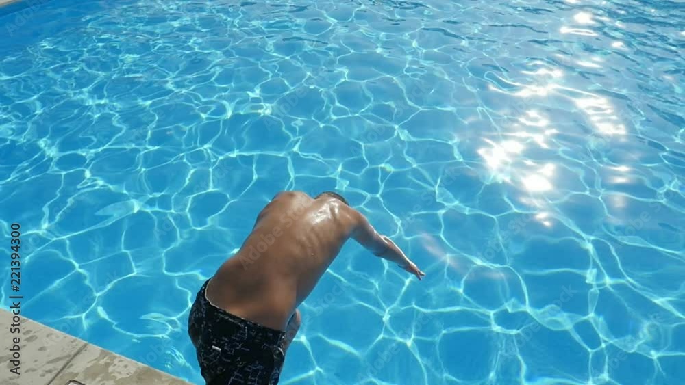 An impressive view of two boys in black shirts jumping in the swimming ...