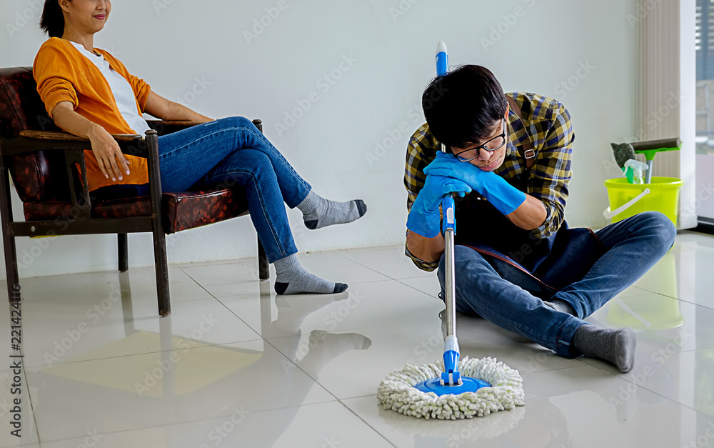 Tired man cleaning his house with equipment in long weekend with relax ...