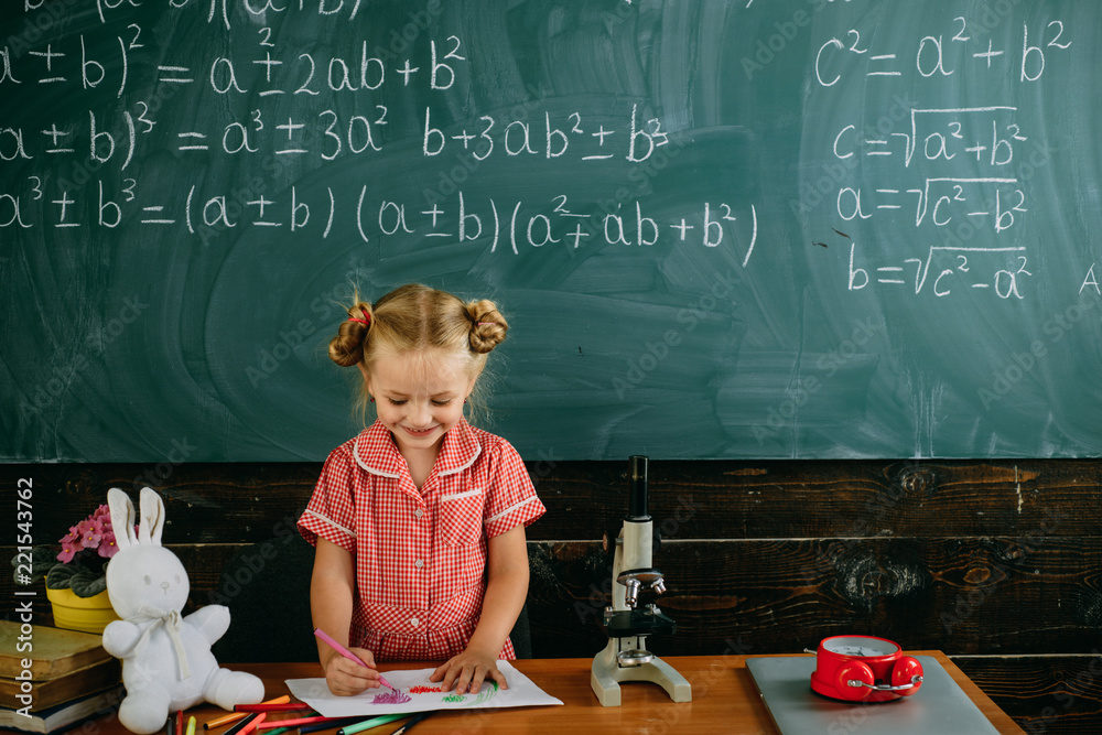 Little girl have lesson in drawing in classroom on chalkboard ...