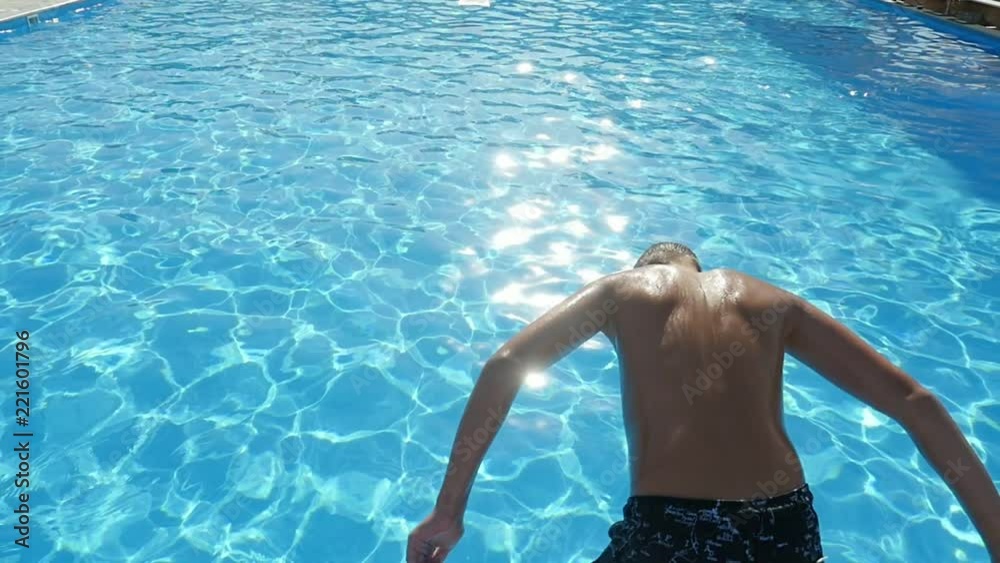 An exciting view of a 12 year old boy in long shorts jumping in the ...