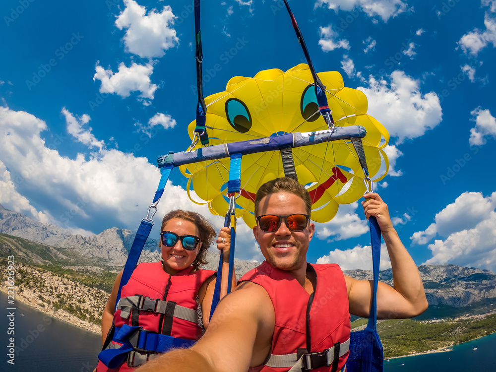 Happy couple on parachute over the se in summer Stock Photo | Adobe Stock