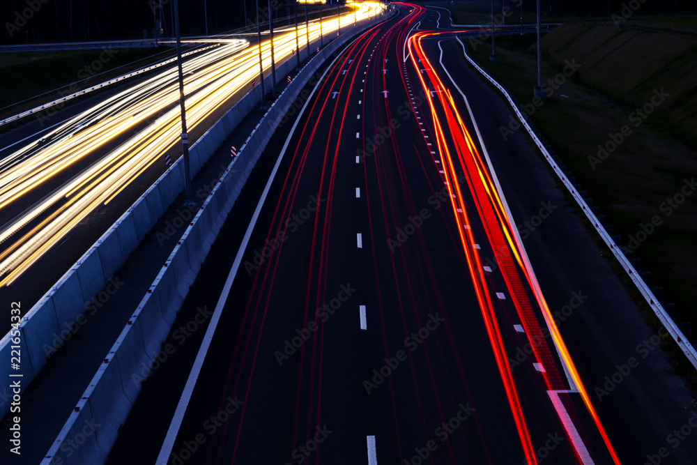 Cars light trails on a curved highway at night. Night traffic trails ...