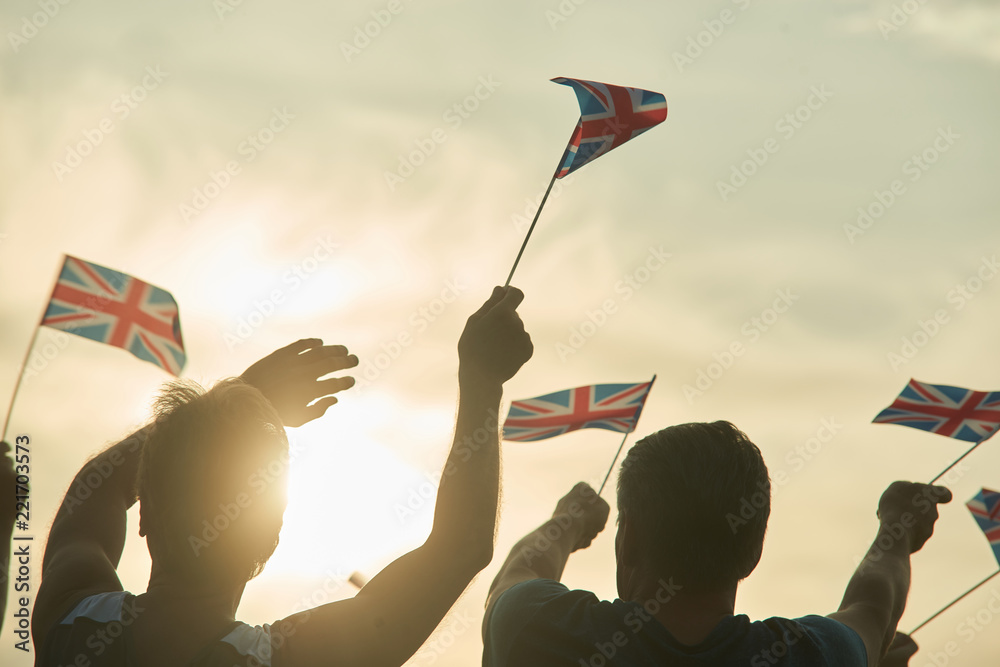 Two men with british flags. Cloudy and sunny sky background. Stock ...