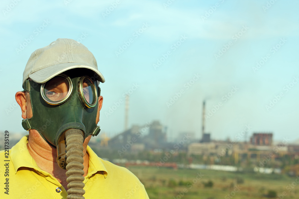 Men in gas mask looks at camera against the industrial factory and ...