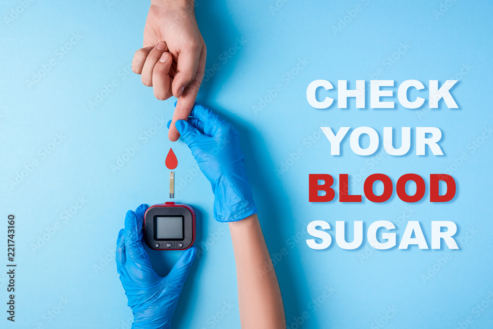 inscription check your blood sugar and Nurse making a blood test. Man's ...