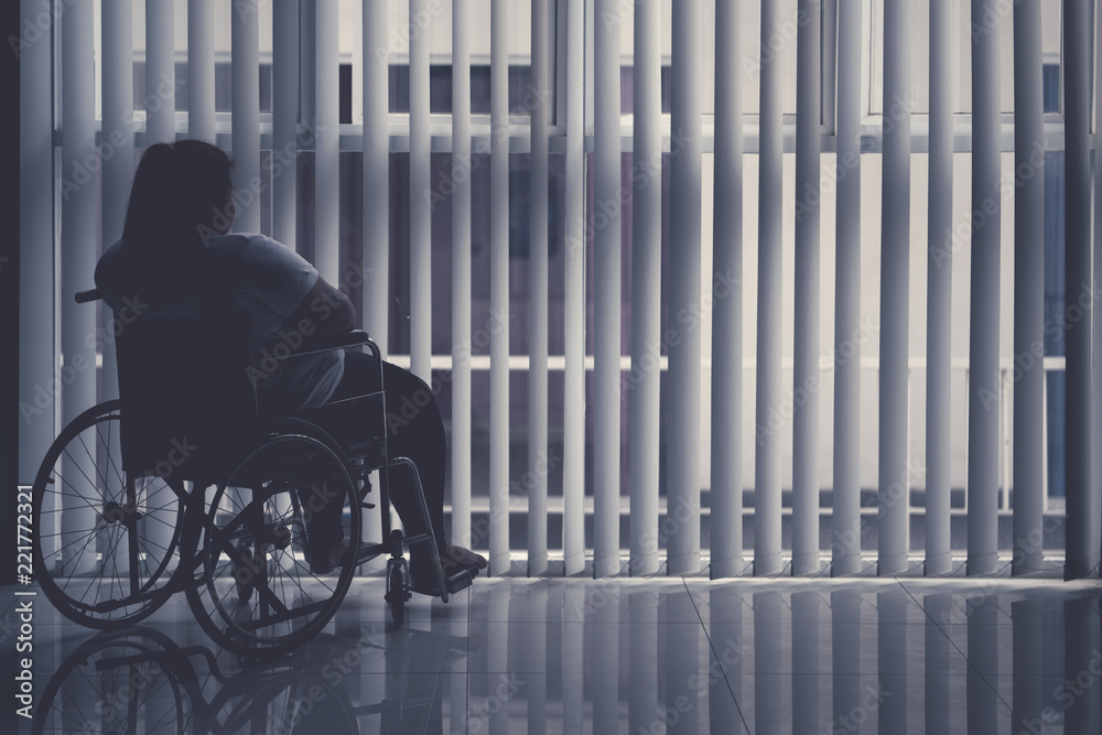 Obese woman sits in the wheelchair by the window Stock Photo | Adobe Stock