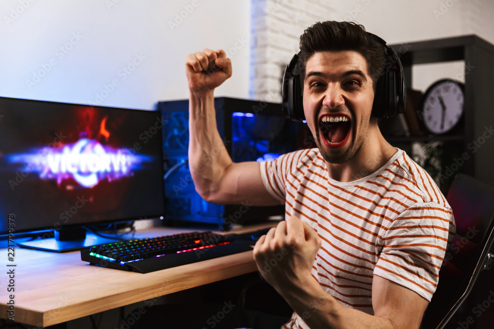 Portrait of caucasian gamer guy screaming and rejoicing while playing ...