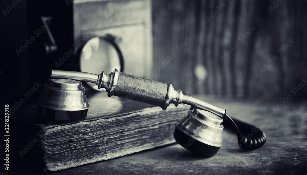 Old telephone and retro book on the desk. The phone of the past on an ...