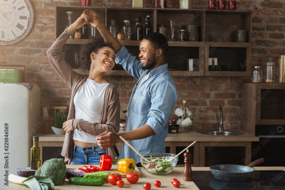 Happy romantic couple dancing in kitchen while cooking Stock Photo ...