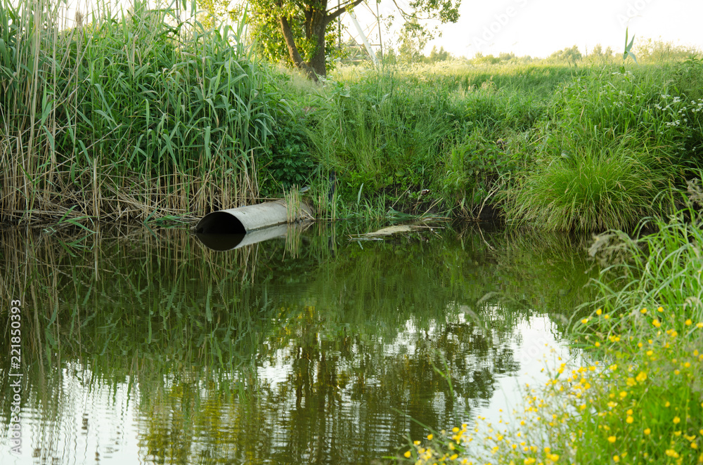 water gushing from the sewer to river/ecology concept: sewer pipe pour ...