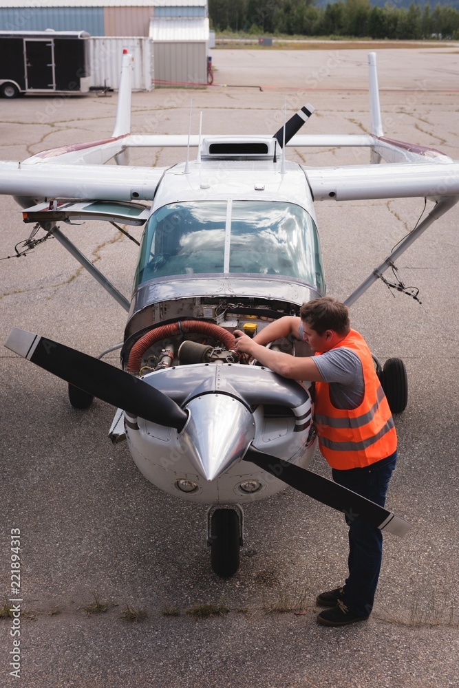 Engineer servicing aircraft engine near hangar Stock Photo | Adobe Stock