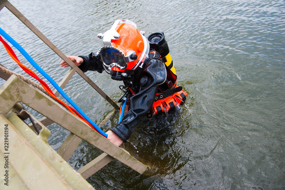 Diver in a diving suit and helmet ready to dive Stock Photo | Adobe Stock