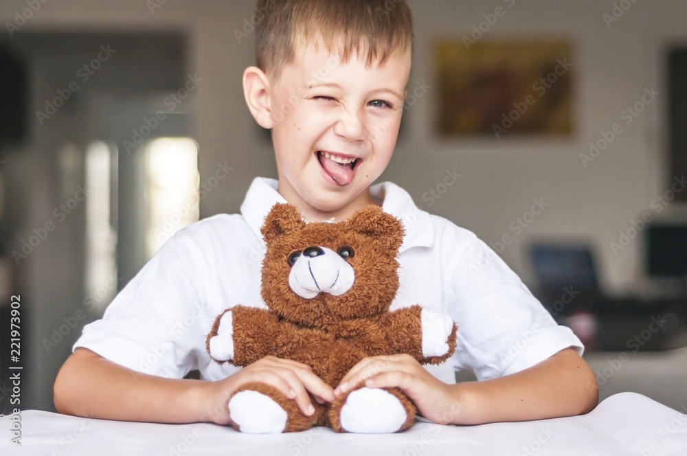 Funny and naughty Caucasian child with a toy teddy bear. Kid showing ...