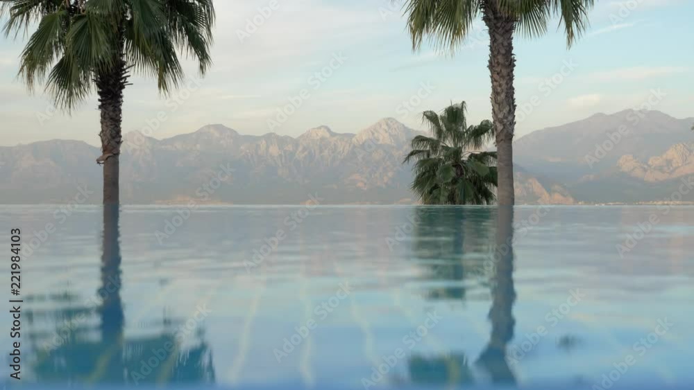 Cinemagraph - rippling water of outdoor swimming pool with palms and ...