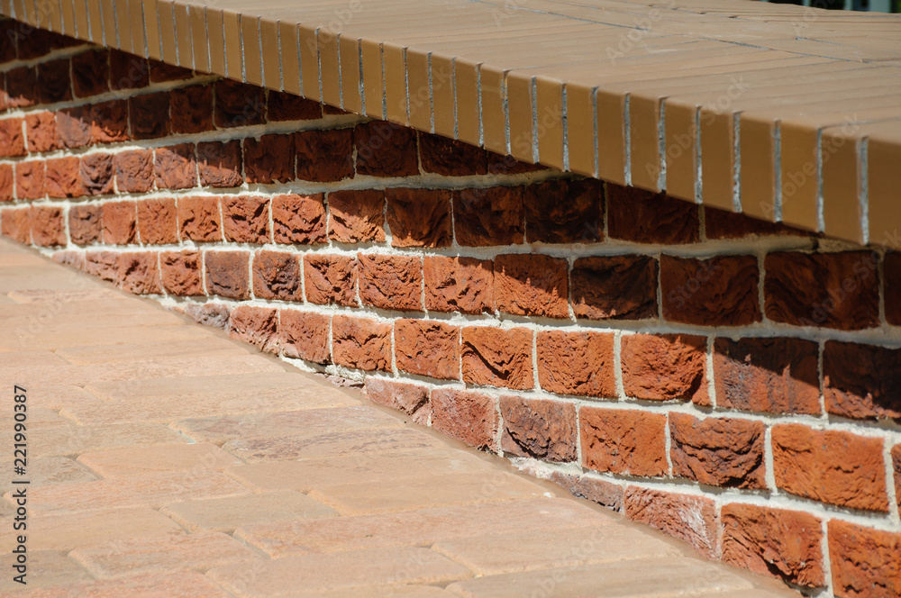 Low parapet made of red and dark red bricks beside brick pavement Stock ...