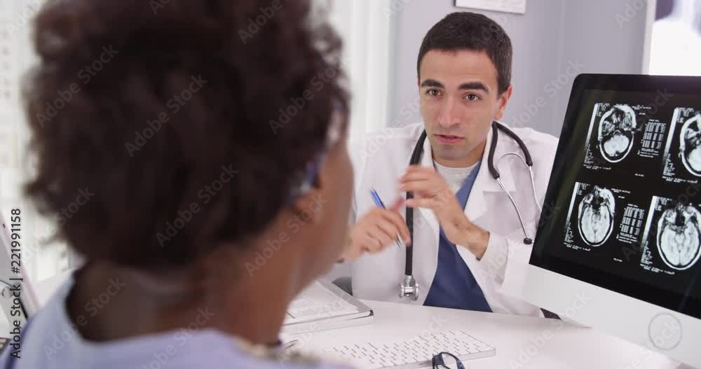Close view of black woman looking at ct-scans of her cranium on doctors ...