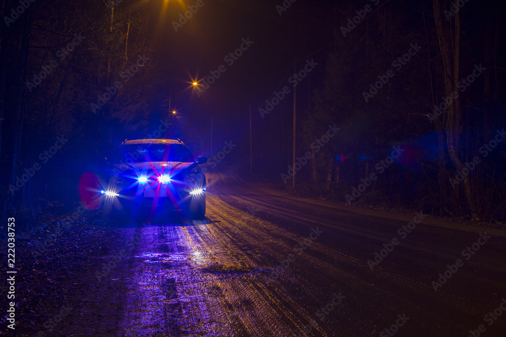 Police car is pulling a driver down on a dark and rainy road. Flashing ...