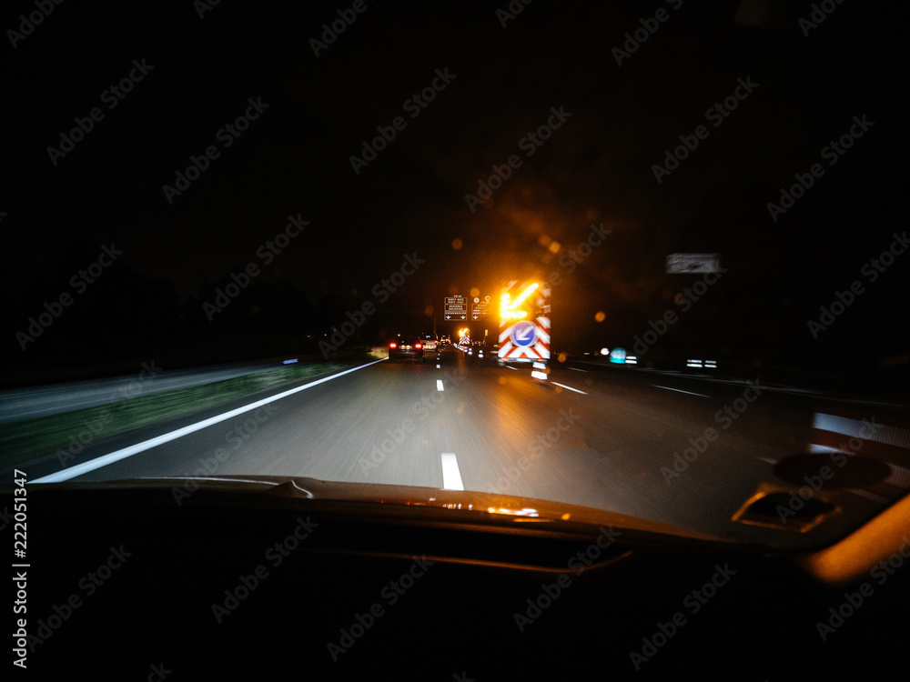 Car Driving Down Road At Night