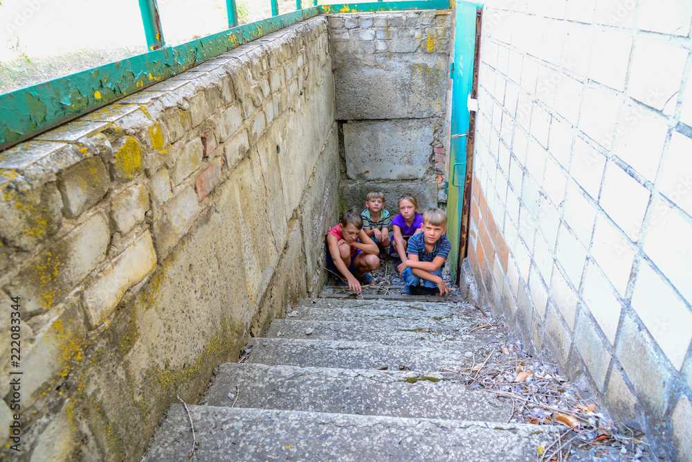 Children in the basement, three boys and a girl near the iron door are ...