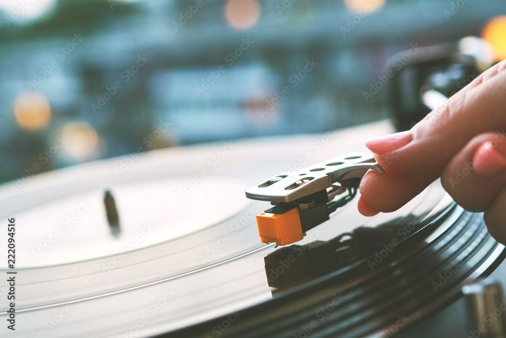 Vinyl player on a sunset background with a bokeh lights of the evening ...