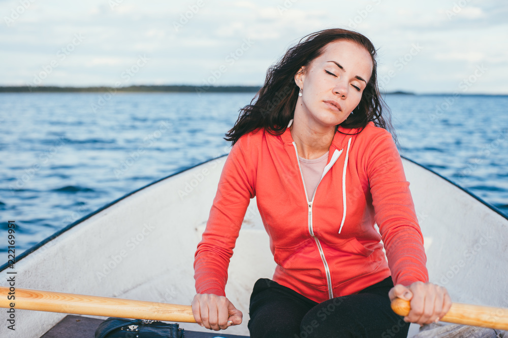amazing beautiful haired girl swims on a wooden boat and rowing with ...