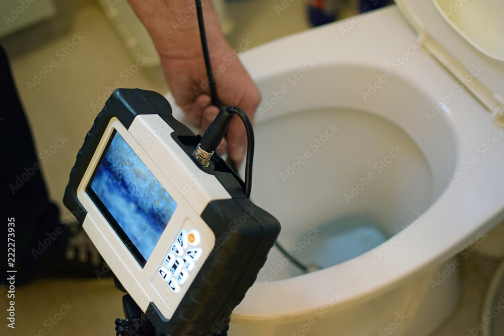 Checking clogged toilet pipe with inspection camera. Stock Photo ...