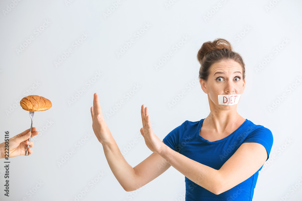 Woman with taped mouth refusing to eat unhealthy food on white ...