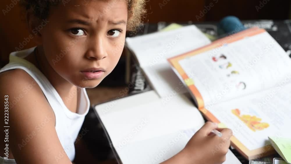 Schoolboy doing homework in his room in the home. Cute african american ...