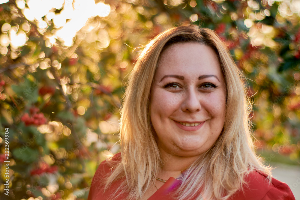 Portrait of a beautiful girl with overweight in a red dress. Close-up ...