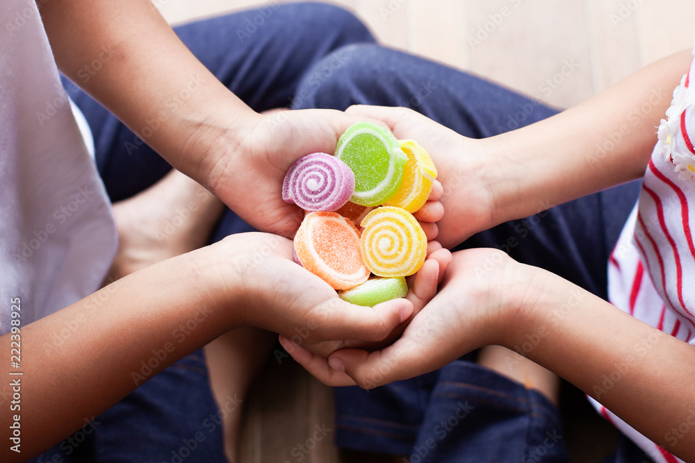 Two asian child girls holding sweet candies in thier hands and share to ...