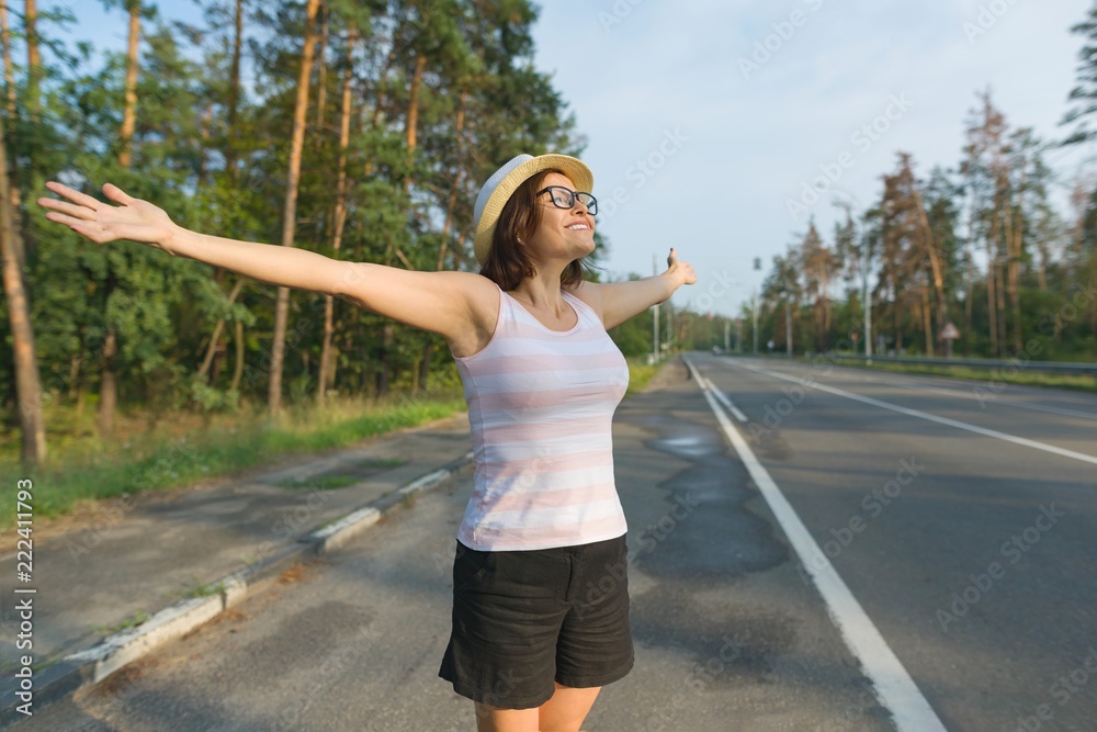Smiling Mature Woman Stands On The Road Spread Her Arms Out To The