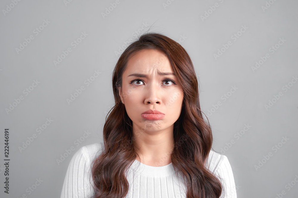 young beautiful sad woman serious and concerned looking worried and thoughtful facial expression ...